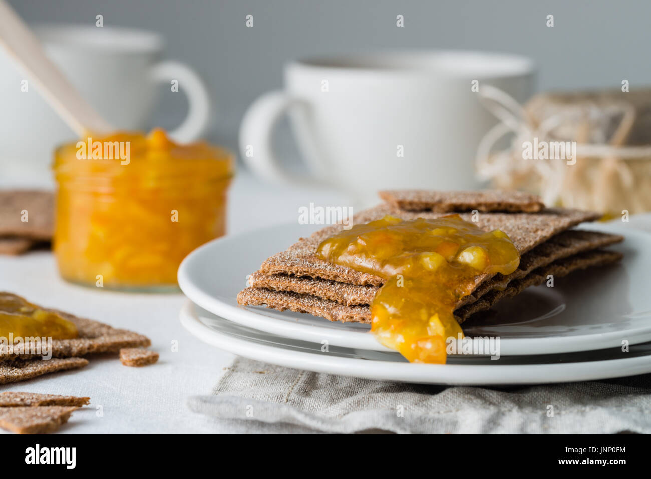 Closeup of brown rye crisp bread (Swedish crackers) with spread orange ...