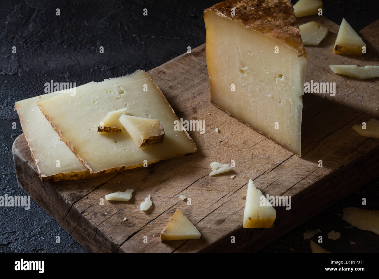 Italian hard cheese pecorino toscano sliced and chopped on wooden board ...