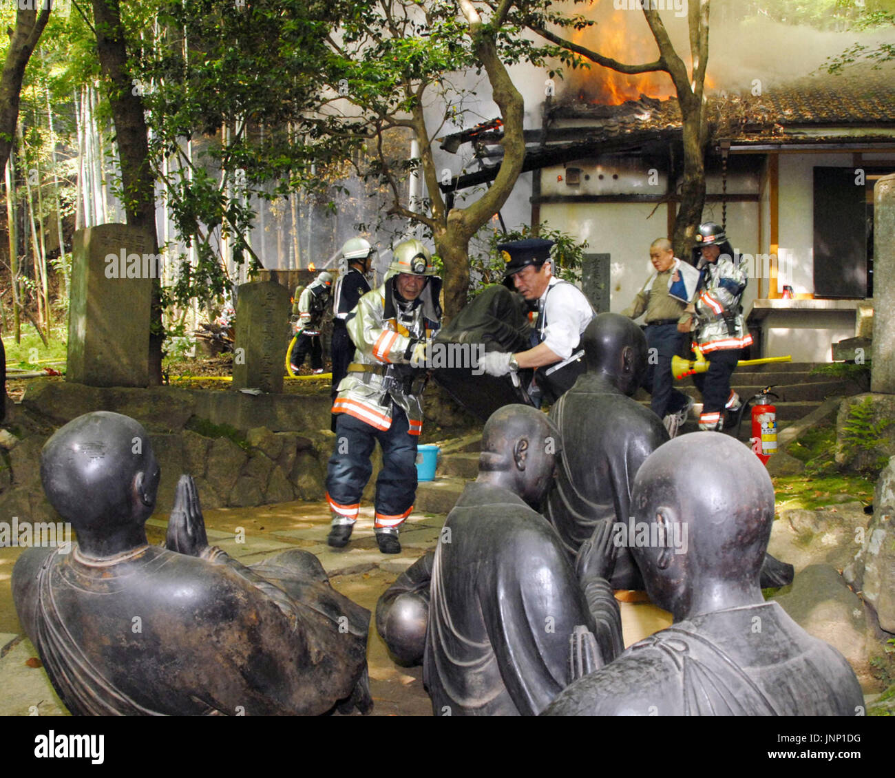 KYOTO, Japan - Firefighters bring wooden statues out from the warehouse ...