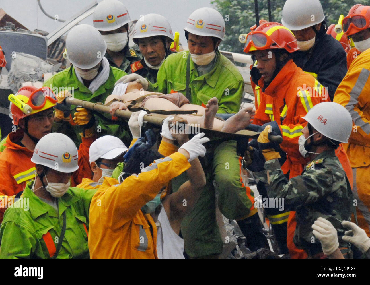 YINGXIU, China - Rescue workers carry a man recovered from the rubble ...