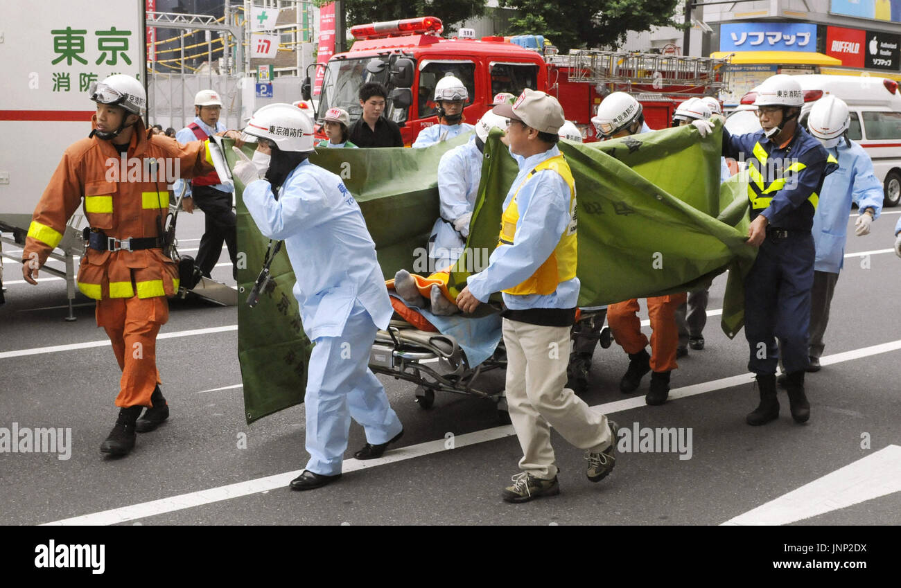 TOKYO, Japan - Emergency services personnel carry a victim of a ...