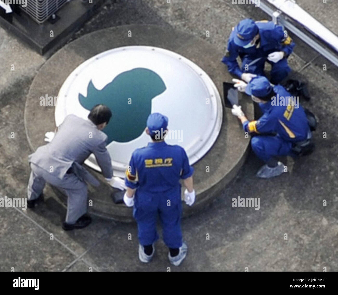 TOKYO, Japan - Police officers check a broken rooftop skylight window ...