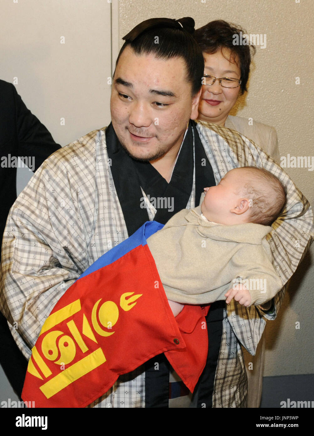 FUKUOKA, Japan - Promotion-chasing sekiwake Ama holds the baby of one ...