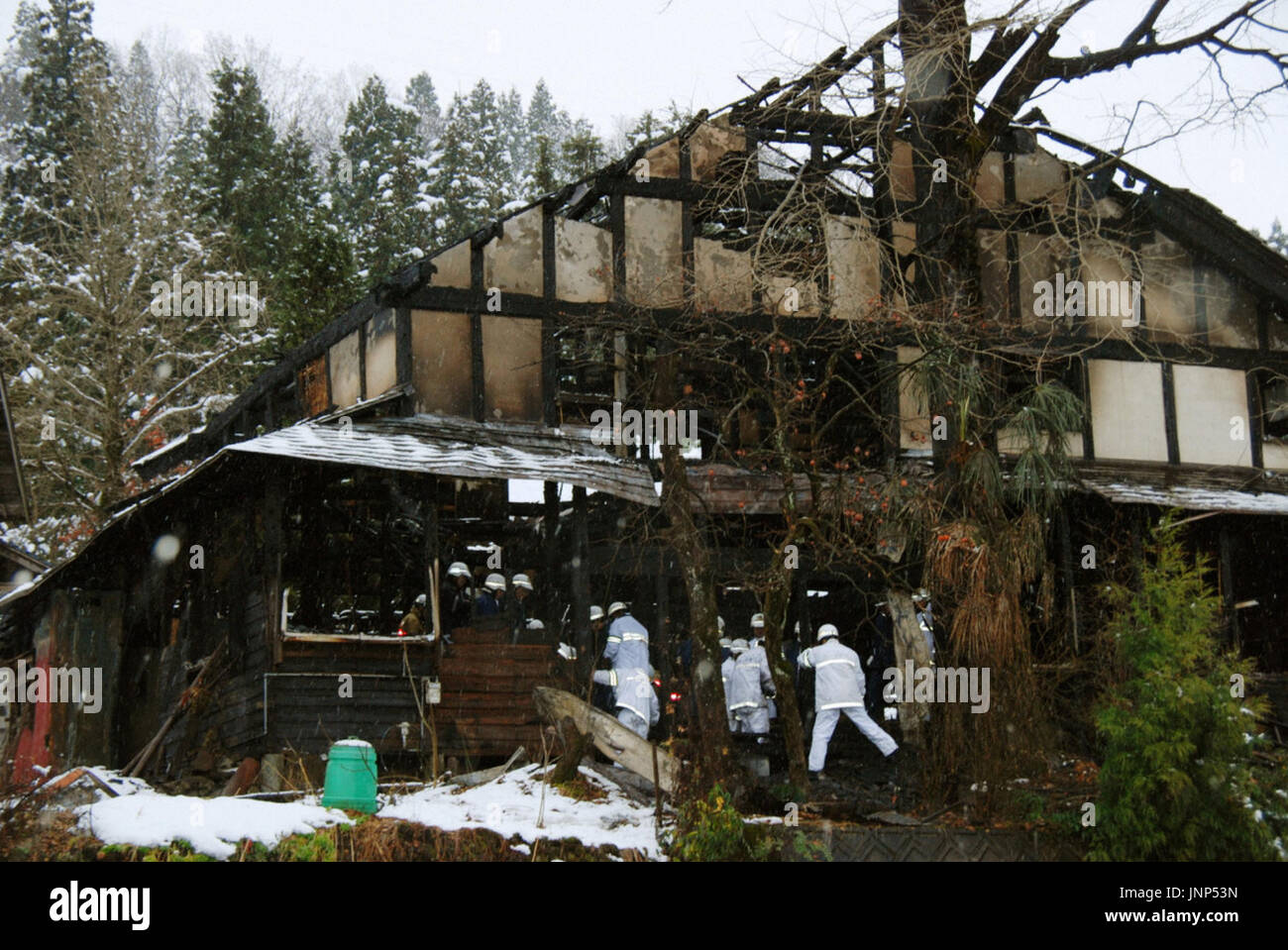 TOYAMA, Japan - Investigators examine a house damaged by a fire that ...