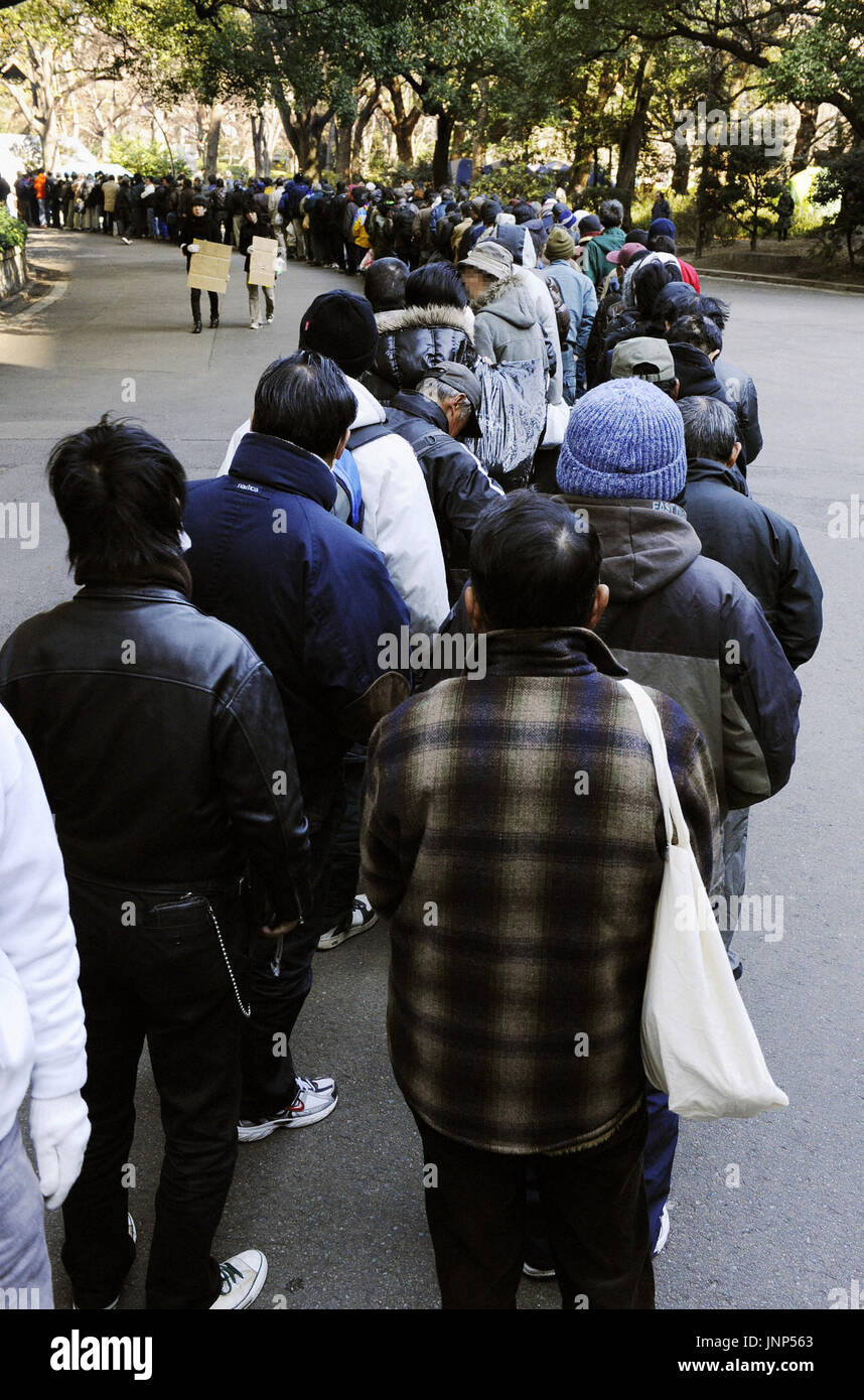 TOKYO, Japan - Homeless people line up to get a meal at a temporary ...
