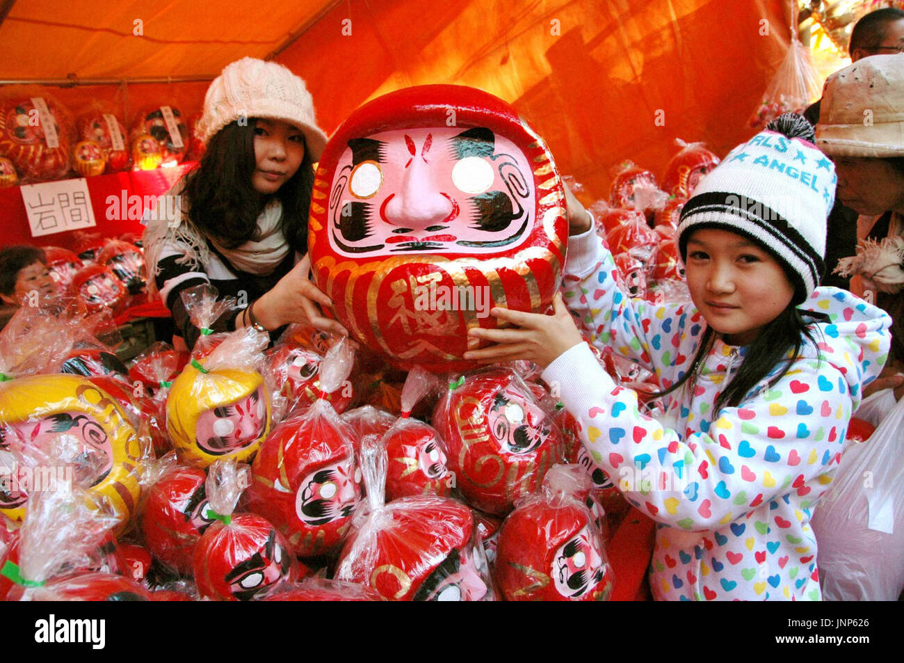 FUJI, Japan - A young customer (R) shows off a Dharma doll at an annual Dharma market at Myohoji ...