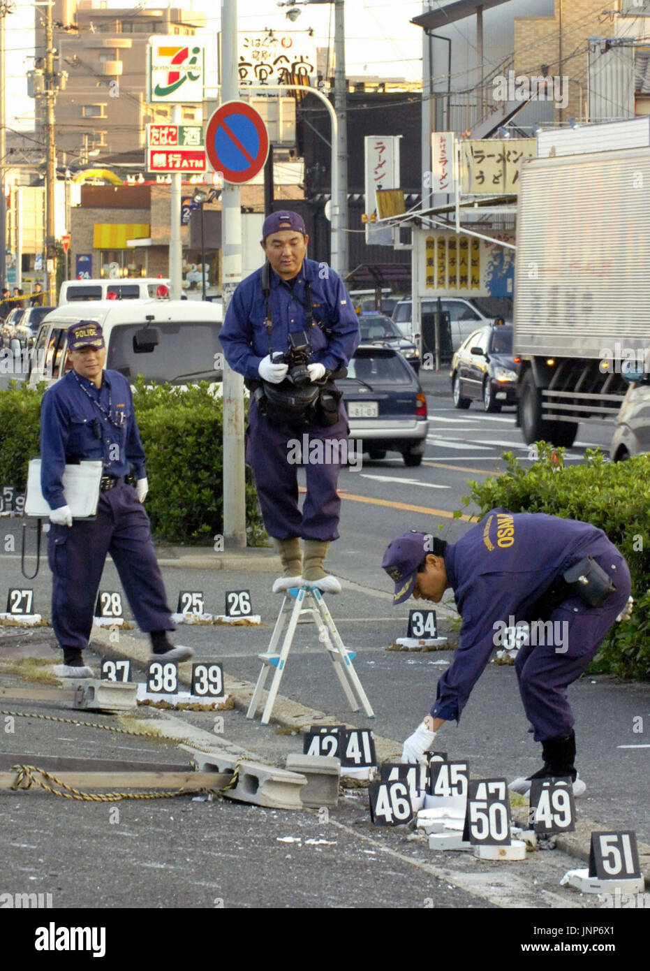 OSAKA, Japan - Police officers investigate a crime scene in Neyagawa ...
