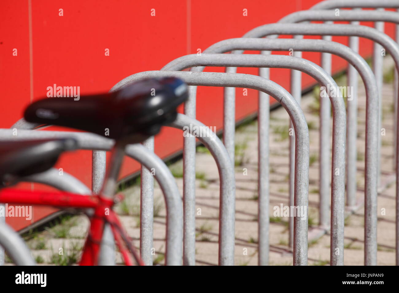 metal Bicycle stand, red house wall Stock Photo - Alamy