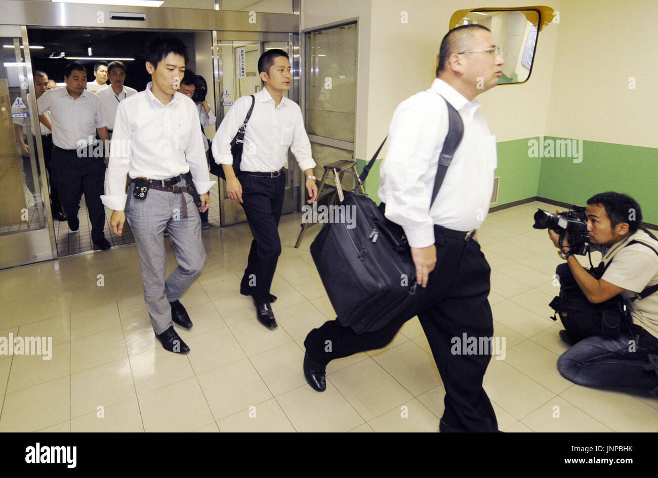 OSAKA, Japan - Investigators head to the headquarters of Mikasa Foods ...
