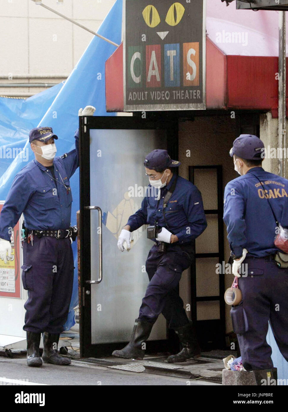 OSAKA, Japan - Police examine a video-viewing establishment in a multi ...