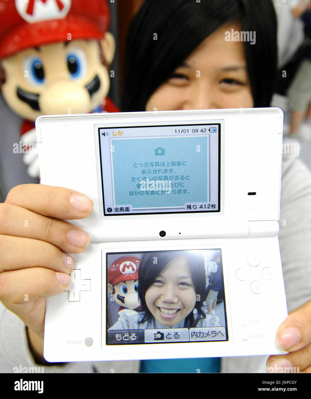 OSAKA, Japan - A woman shows off Nintendo Co.'s DSi, a new version of ...