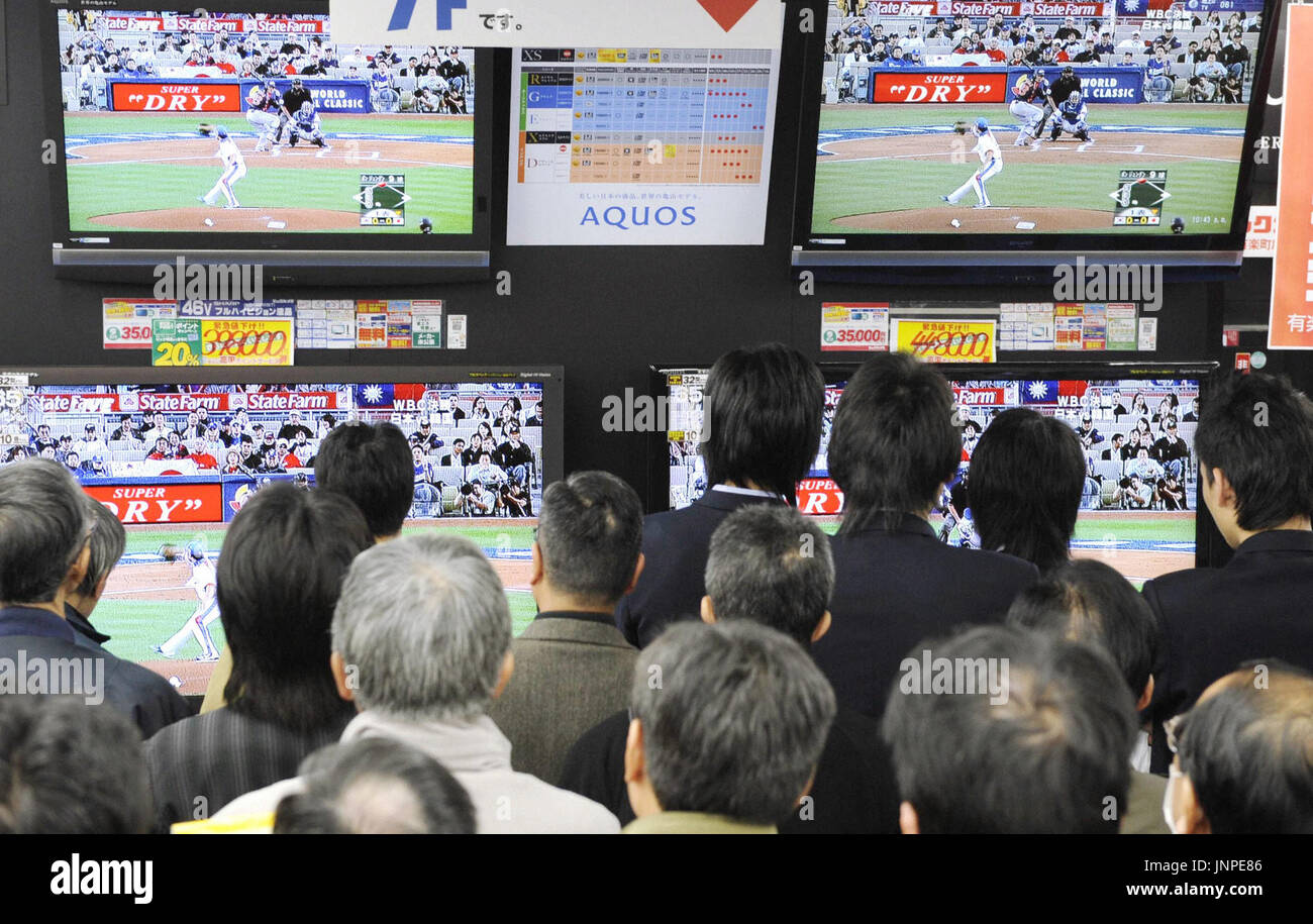 TOKYO, Japan - People watch a TV program airing the World Baseball Classic final between Japan ...