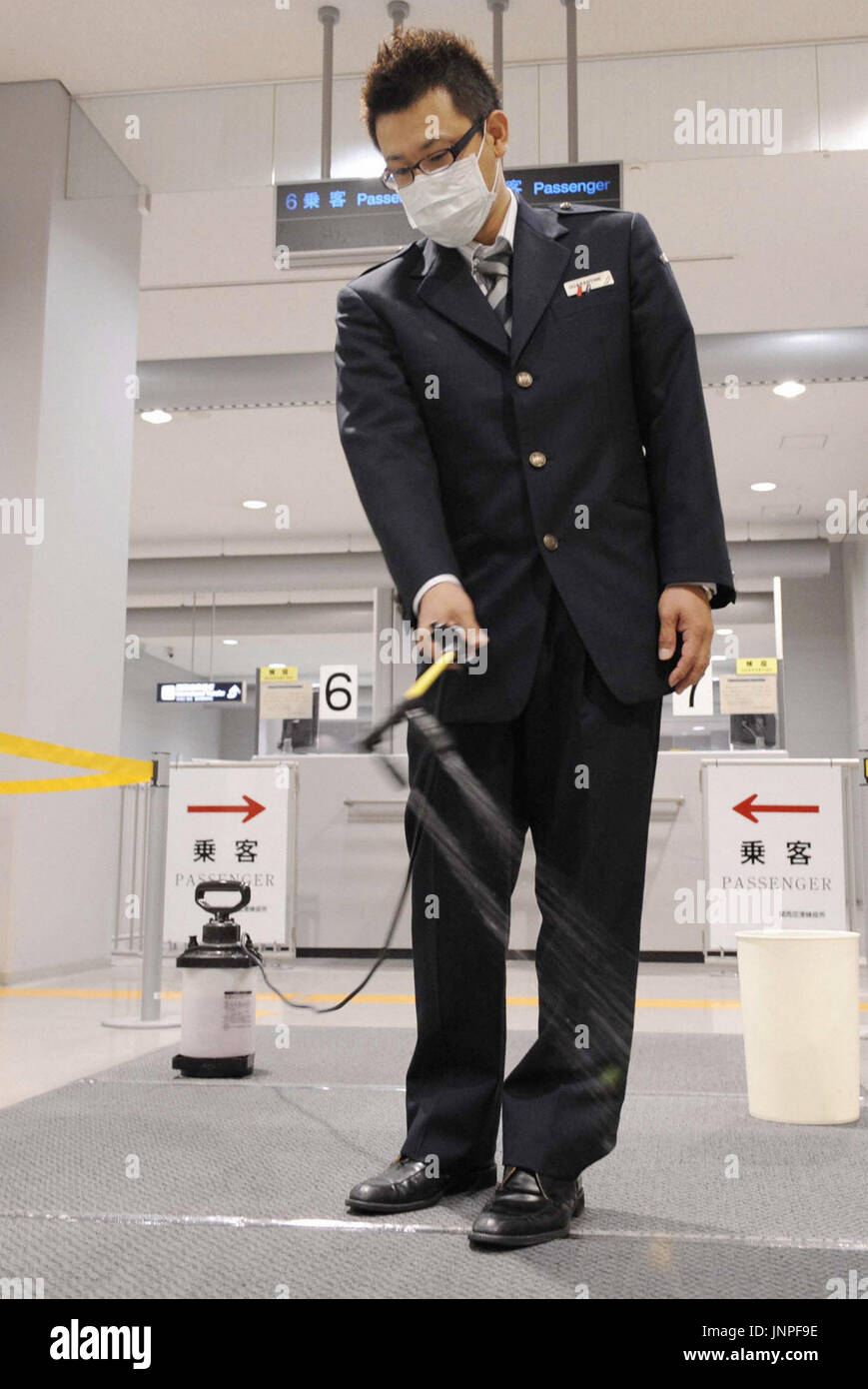 OSAKA, Japan - A quarantine officer sprays antiseptic solution on the ...