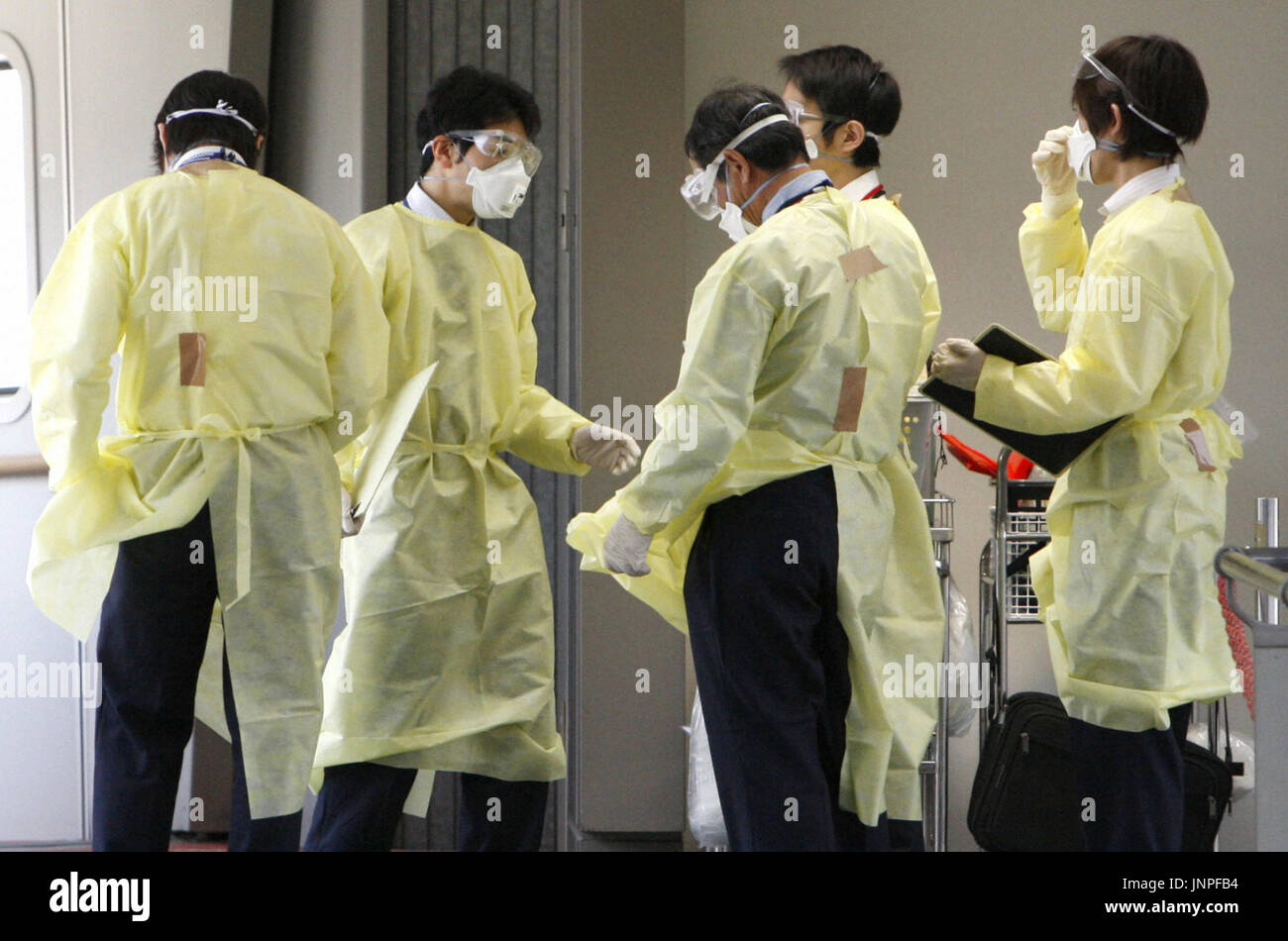 NARITA, Japan - Quarantine officers head to an airplane arriving from ...