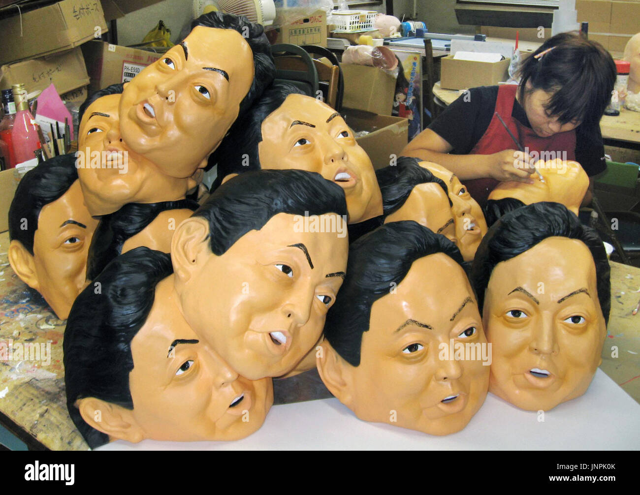 SAITAMA, Japan - A worker colors rubber masks of Japanese Prime ...