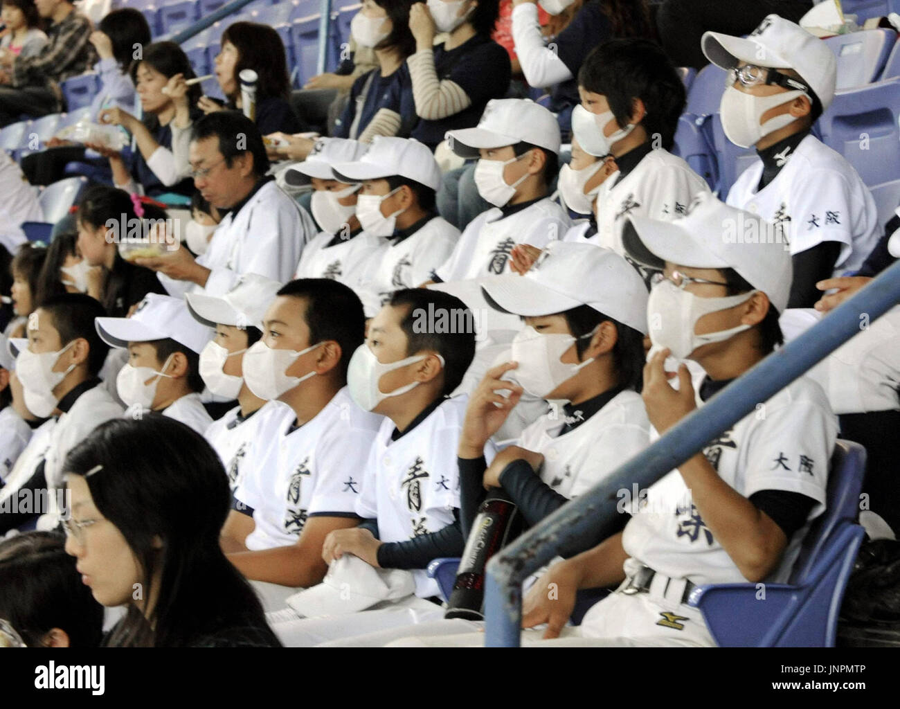 OSAKA, Japan - A group of boys wearing protective masks watch a ...
