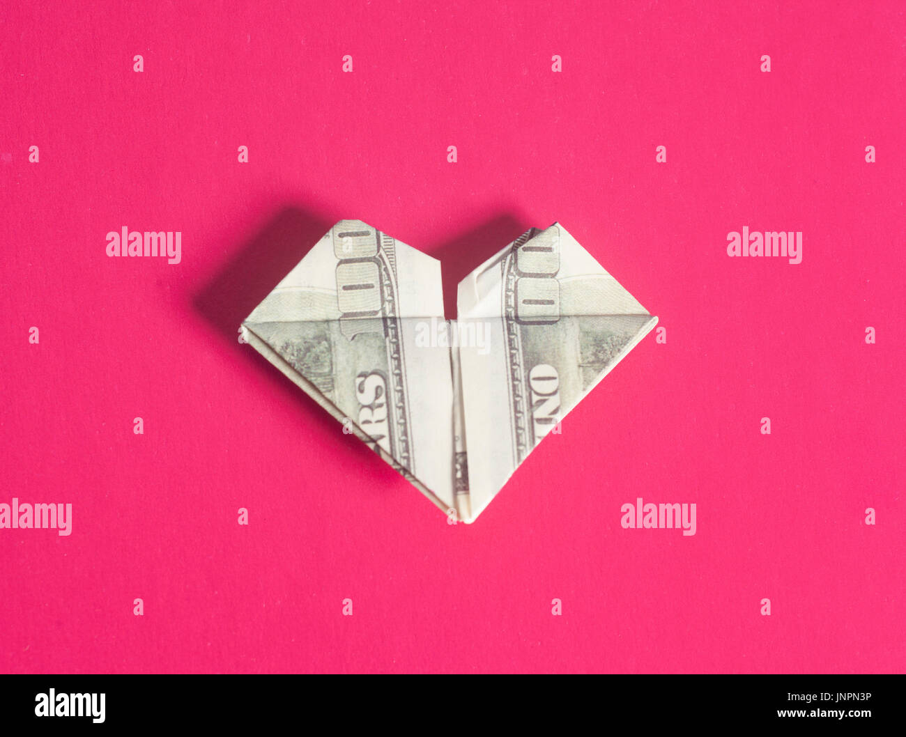 Dollar US bills in heart shape origami Stock Photo - Alamy