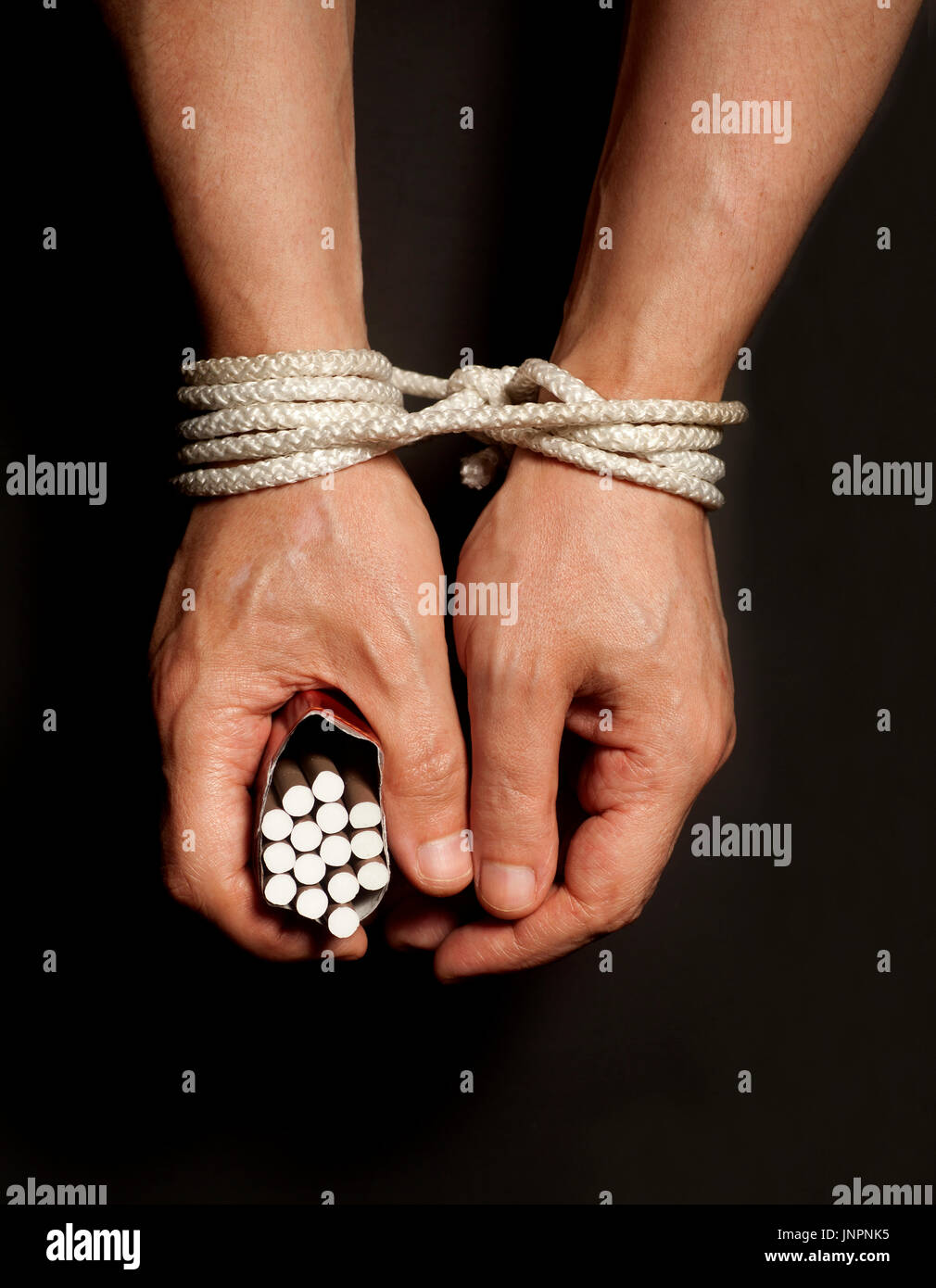 Tobacco addiction. Cigarettes on male hands tied with a rope Stock ...