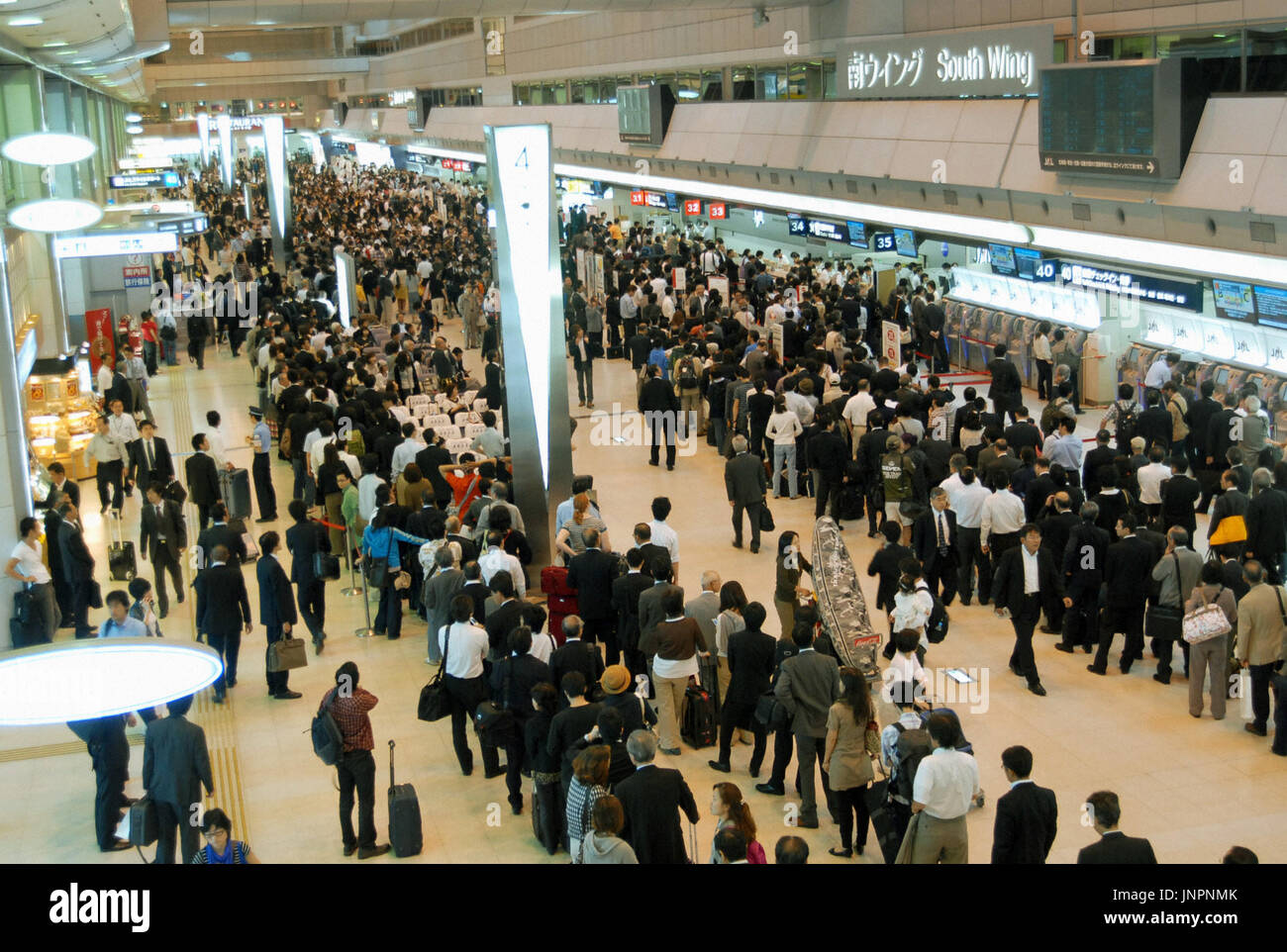 TOKYO, Japan - Passengers form a long line at ticket counters to change ...