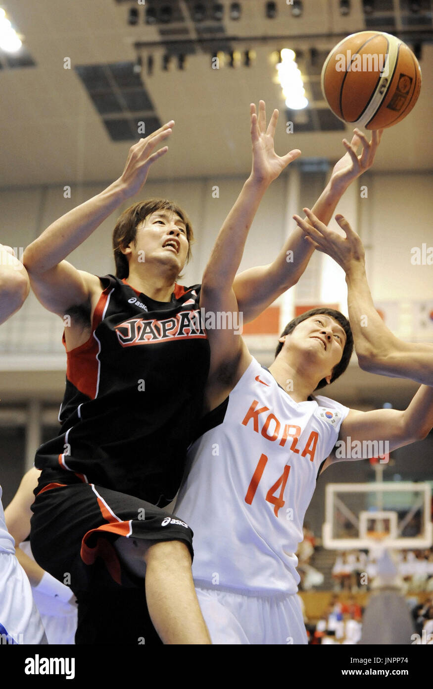 KOMAKI, Japan - Japan's Kosuke Takeuchi (L) goes up to shoot as South ...