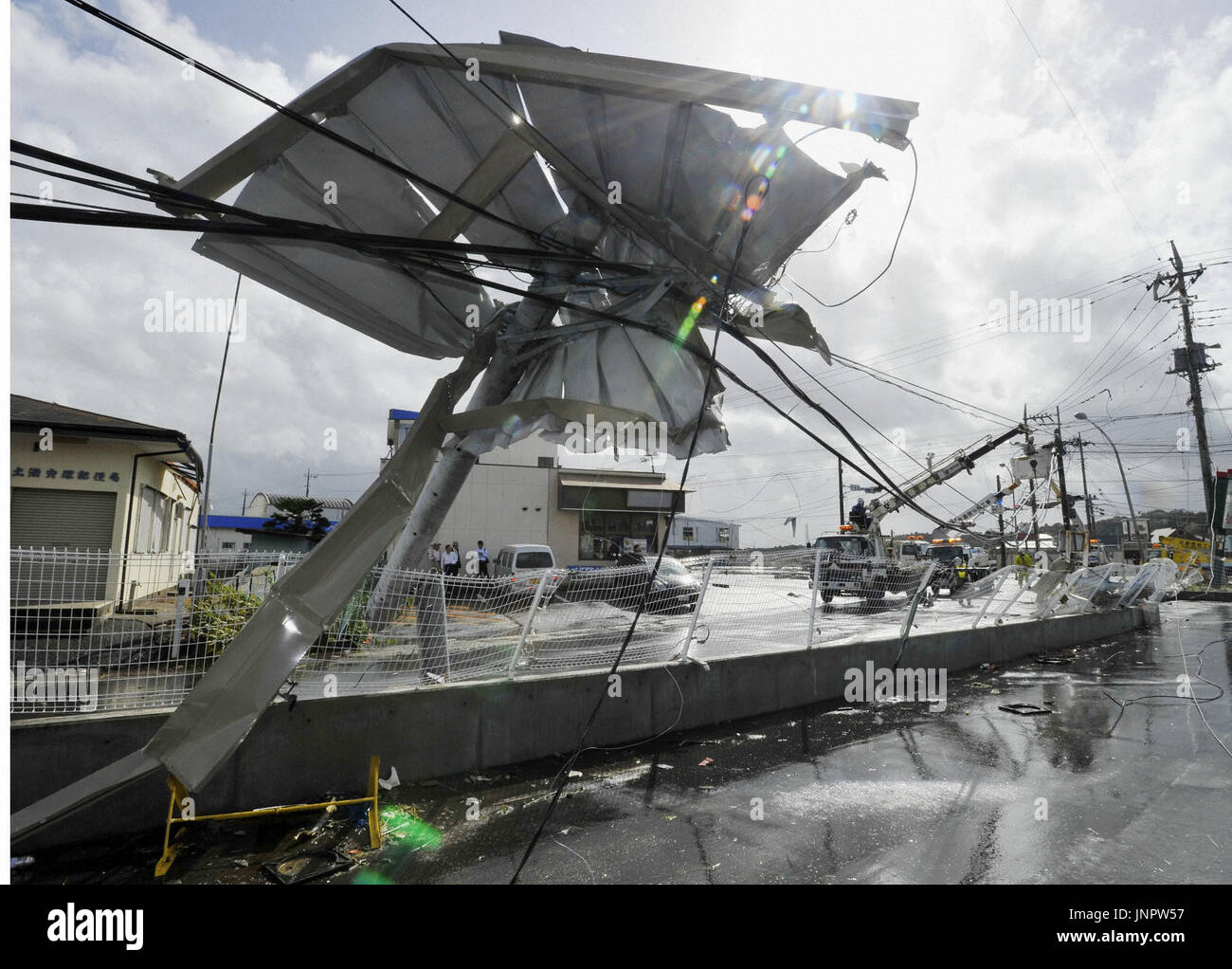 TOKYO, Japan - Material from a house hangs over a utility pole that is ...