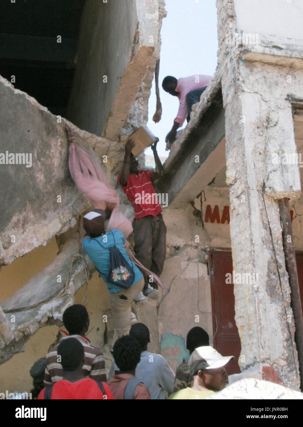 PORT-AU-PRINCE, Haiti - People plunder boxes of goods from a destroyed ...