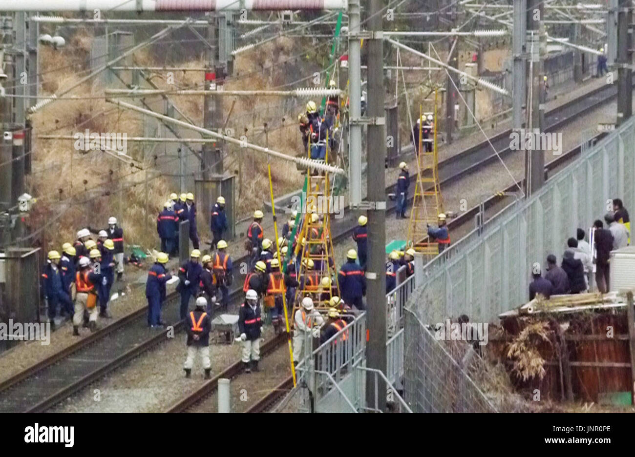 TOKYO, Japan - Railway workers work on restoring a snapped overhead ...