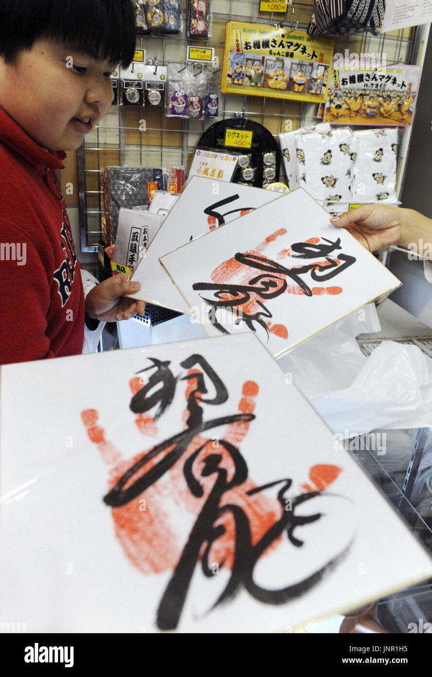 TOKYO, Japan - A boy buys a card bearing the autograph and handprint of ...