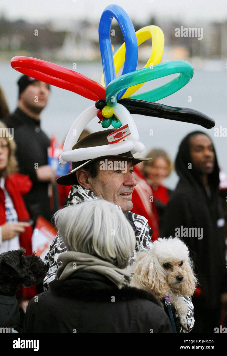 VANCOUVER, Canada - A man wears balloons in Olympic colors on his head ...