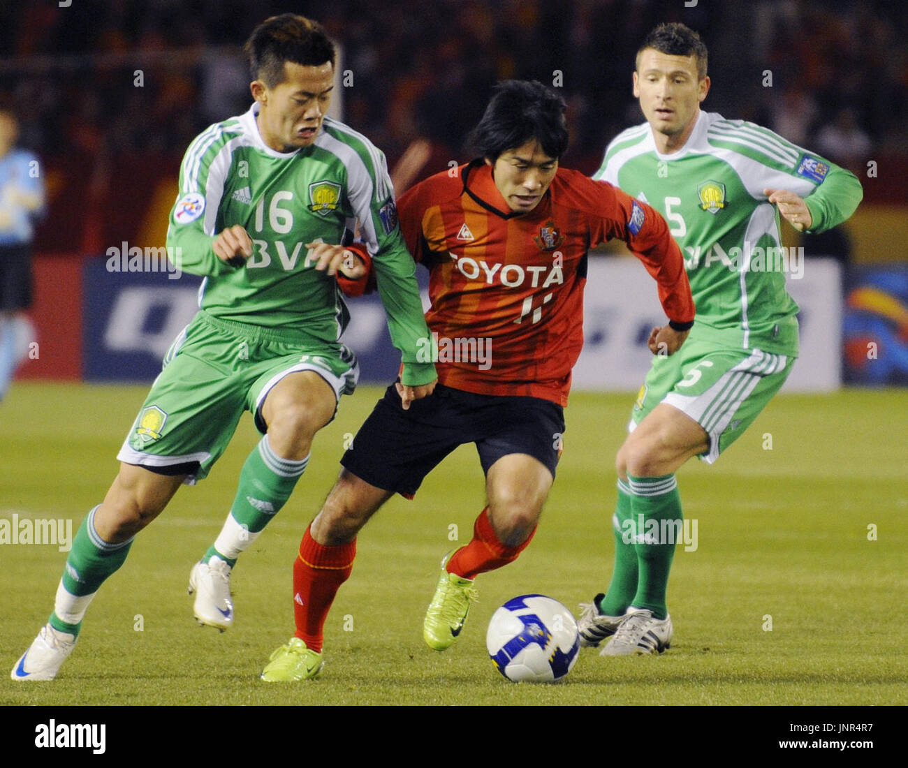NAGOYA, Japan - Japan's Nagoya Grampus forward Keiji Tamada (C) battles ...