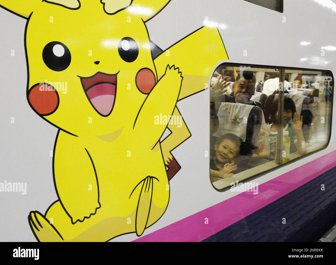 TOKYO, Japan - Passengers wave from a Shinkansen bullet train painted ...