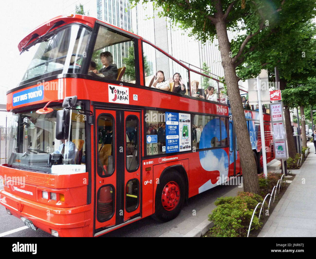 TOKYO, Japan - Sightseers on a bright red, open-top double-decker take ...