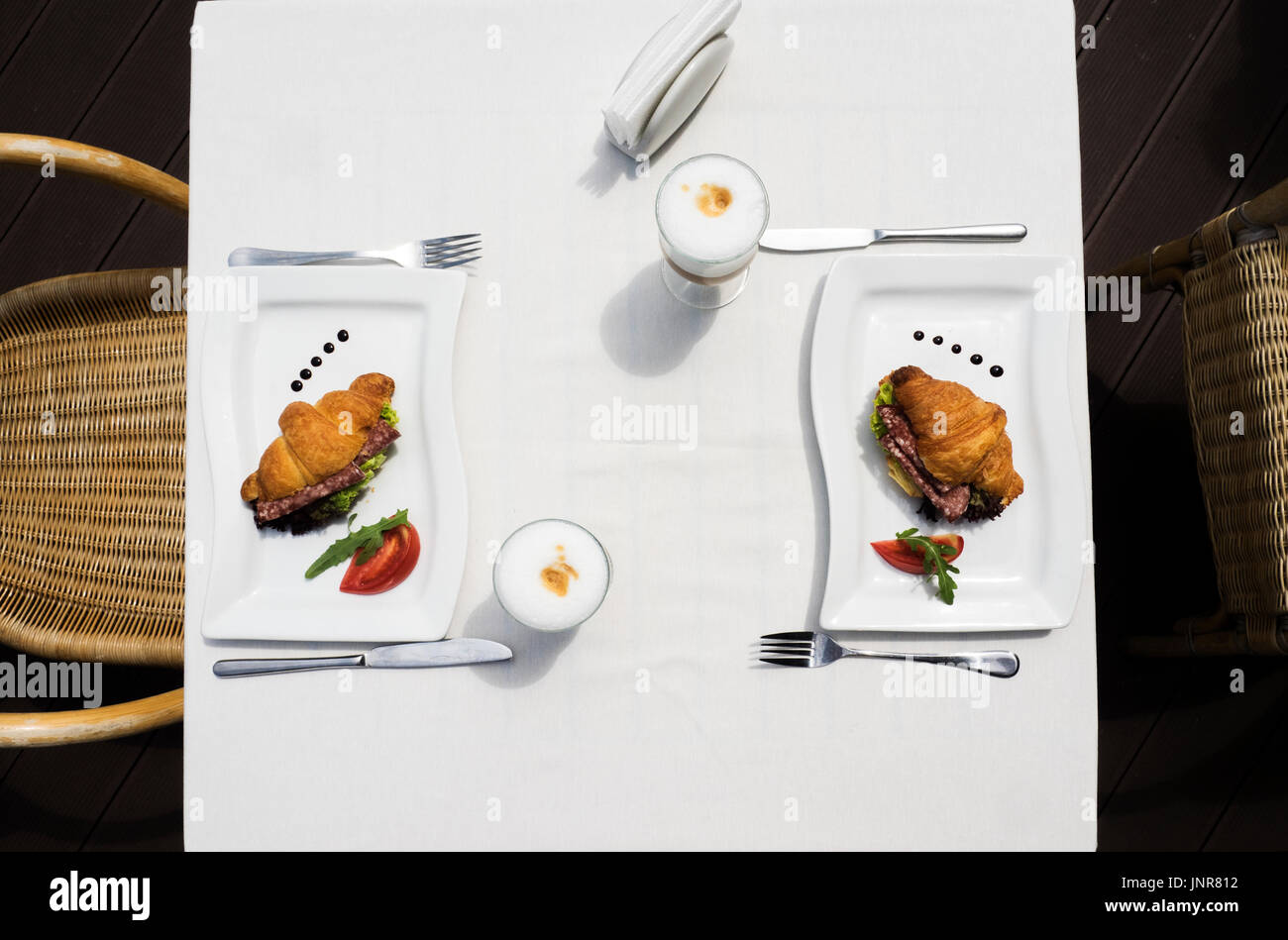 Table set for breakfast with coffee and croissants Stock Photo - Alamy