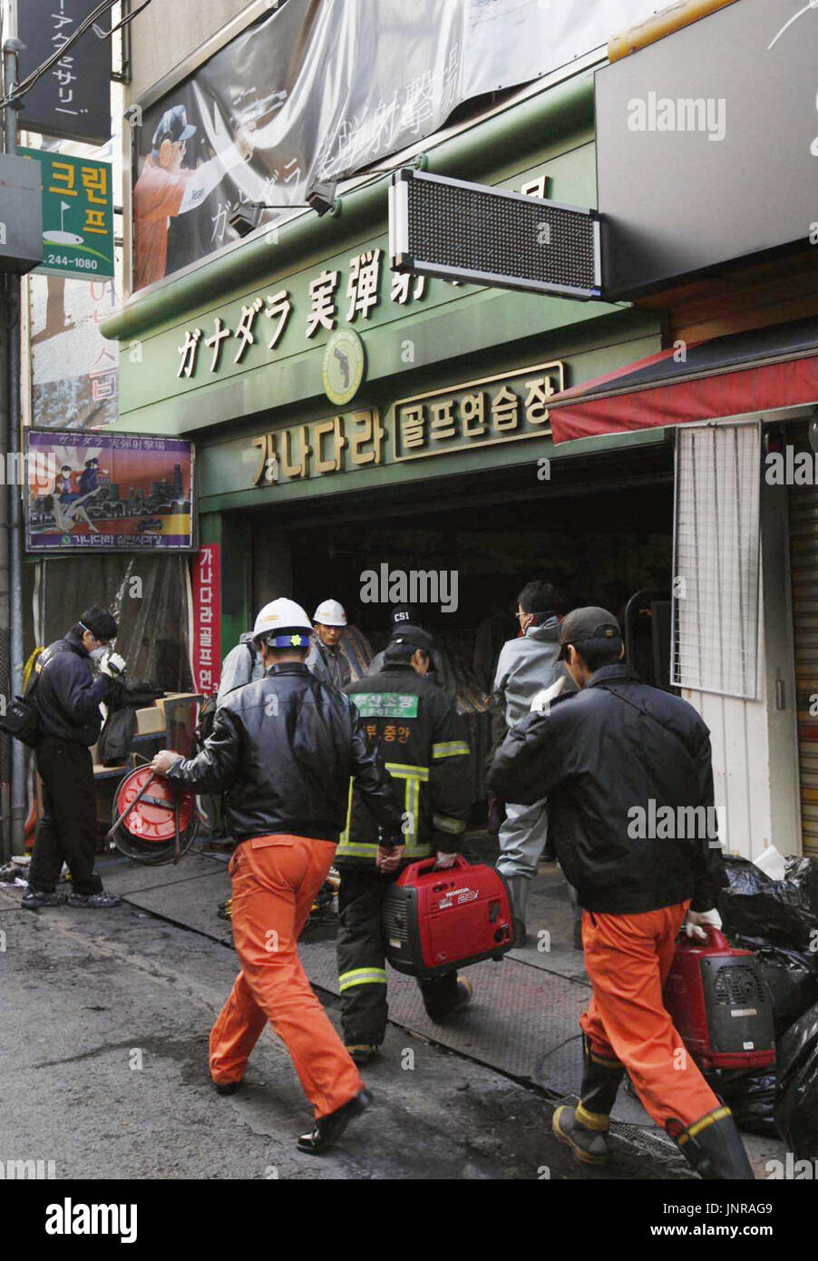 BUSAN, South Korea - Firefighters and police officers enter a building ...
