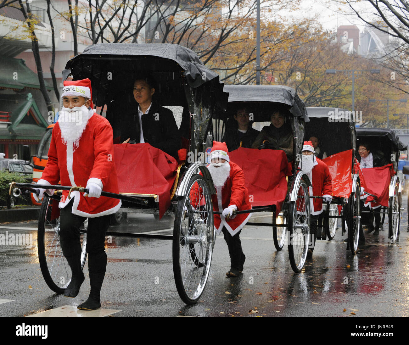 TOKYO, Japan - Men dressed as Santa Claus pull rickshaws for tourists ...
