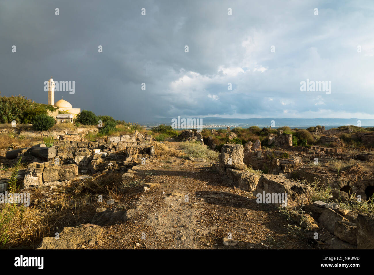 Path with sunlight during storm in ruins with dramatic cloudscape in ...