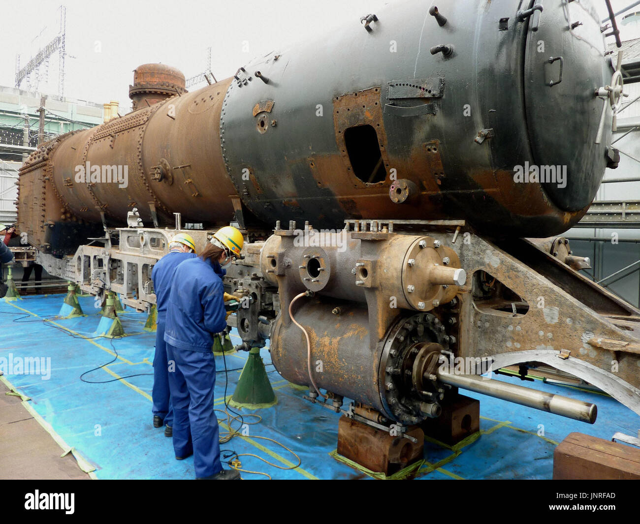 SAITAMA, Japan - Mechanics check the main body and parts of a C61 steam ...