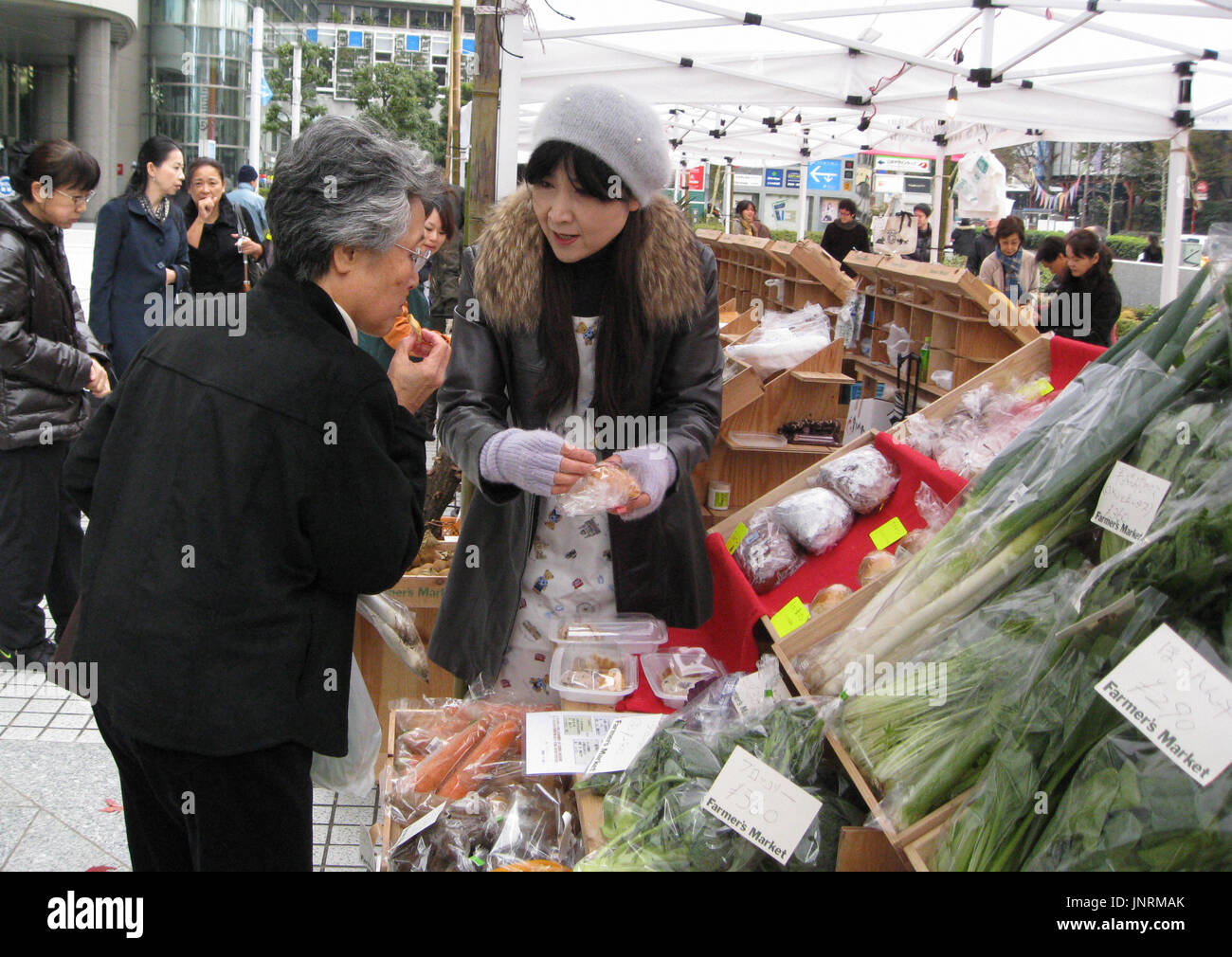 TOKYO, Japan - A woman samples produce at a farmers market in Tokyo's ...