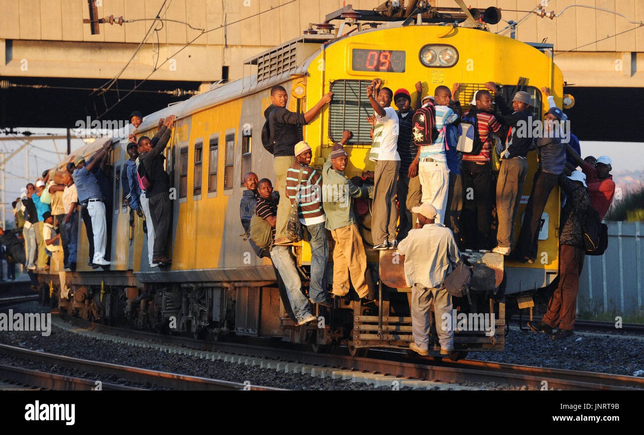 JOHANNESBURG, South Africa - People cling to an overcrowded commuter ...
