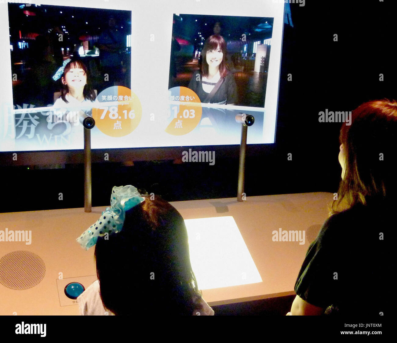 TOKYO, Japan - Visitors compete in a 'Smile Fight' game at Sony ...