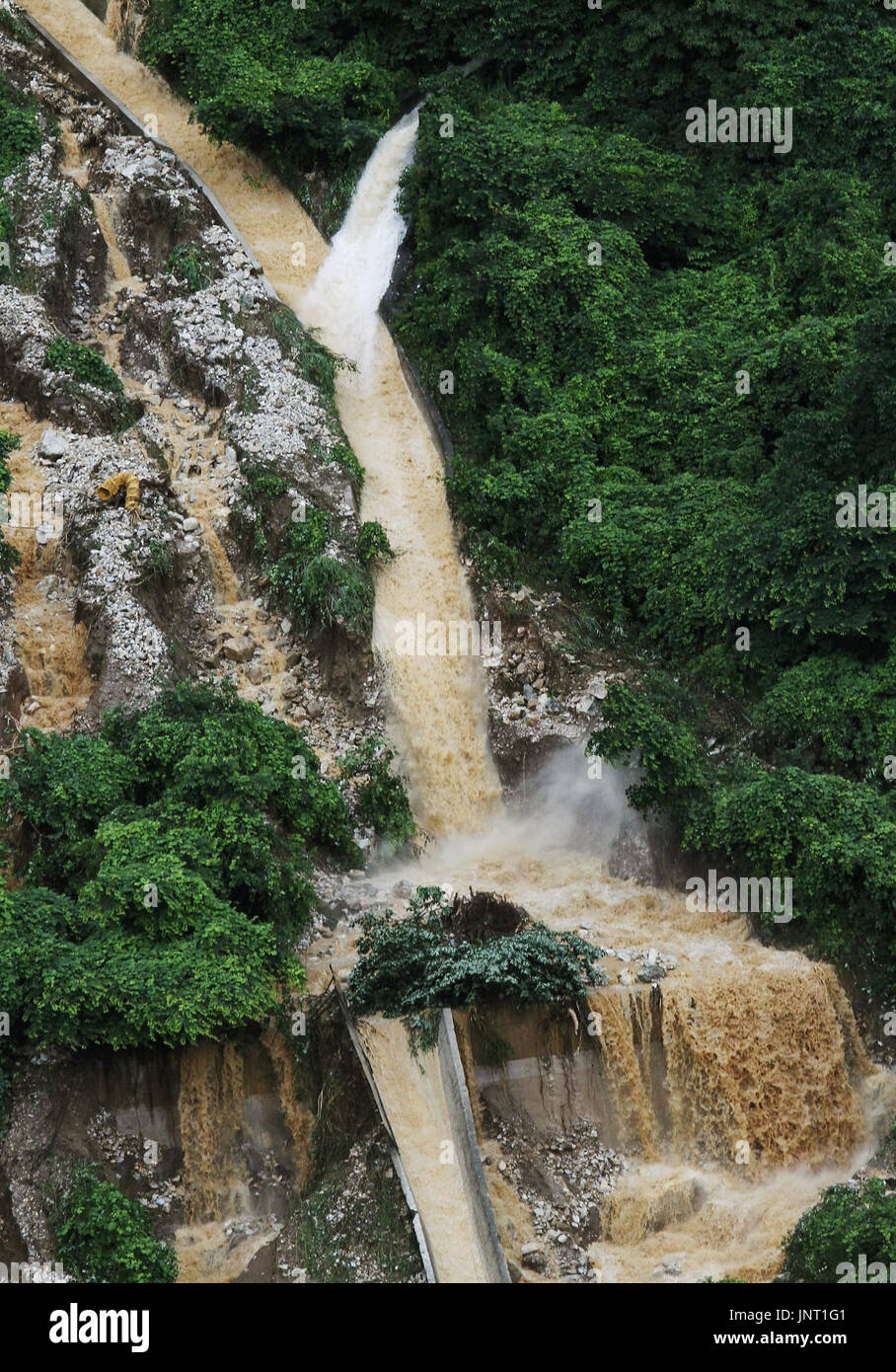 FUKUOKA, Japan - Muddy water flows like a waterfall on a mountain in ...