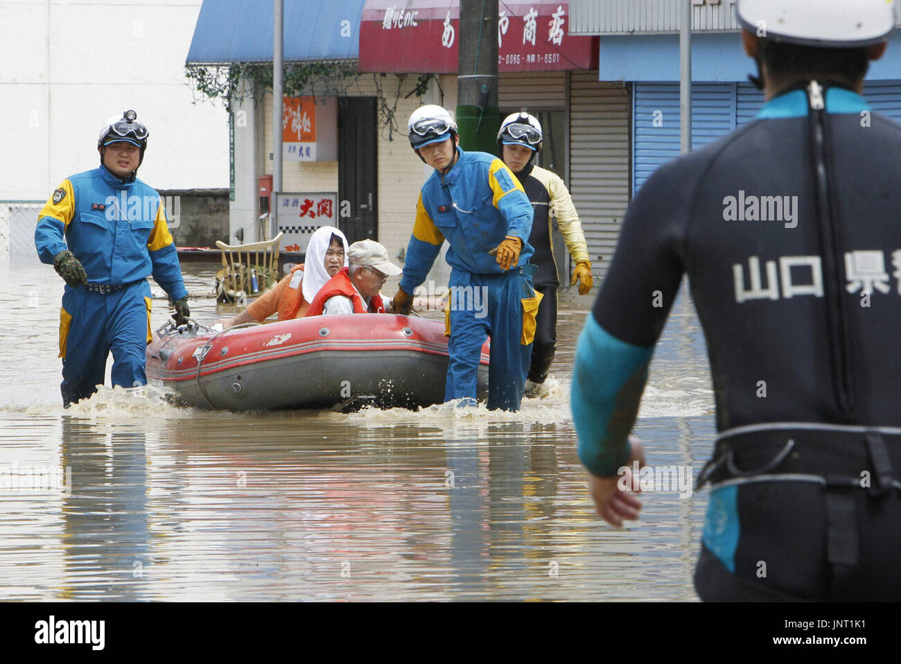 SANYO-ONODA, Japan - Rescue workers pull a rubber boat carrying ...