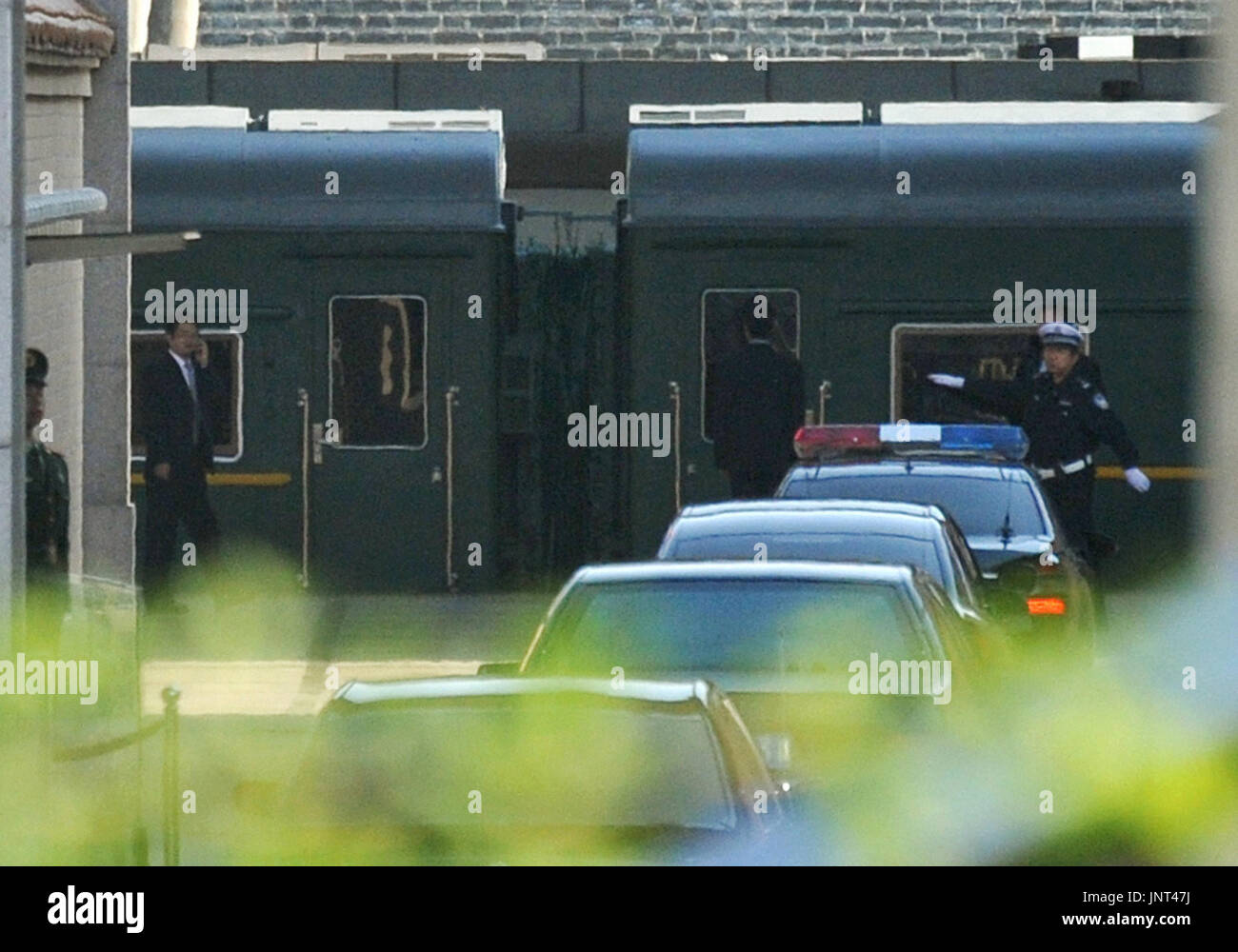 BEIJING, China - A police car leads a motorcade, including a car ...