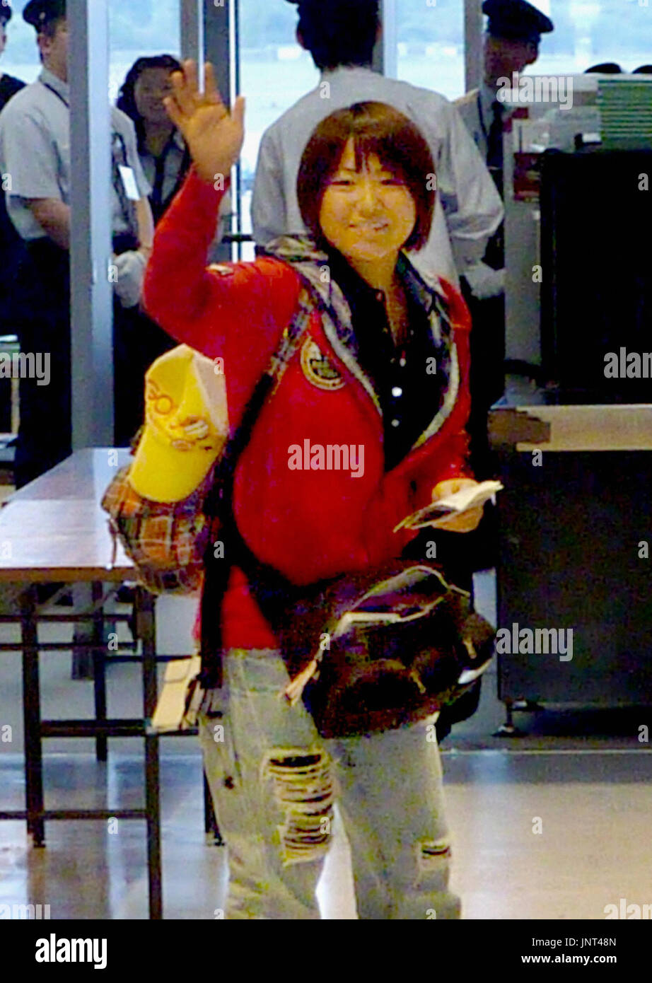 NARITA, Japan - Japanese female knuckleballer Eri Yoshida waves as she prepares to leave Narita ...