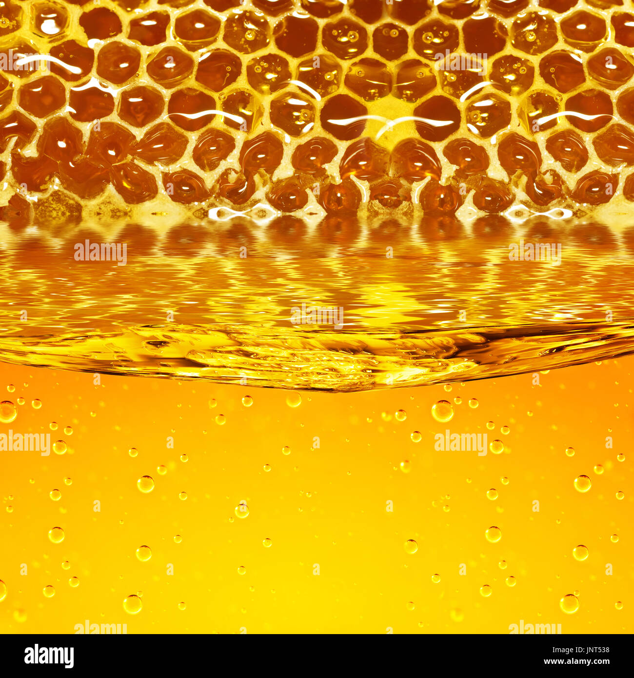Golden honey flowing down honeycombs hi-res stock photography and ...