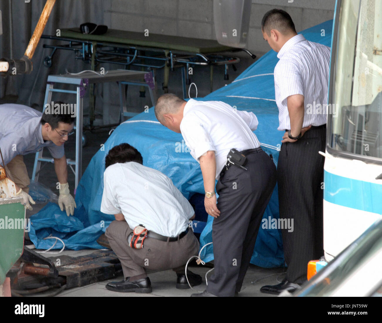 HIROSHIMA, Japan - Police officers examine a car driven by Toshiaki ...