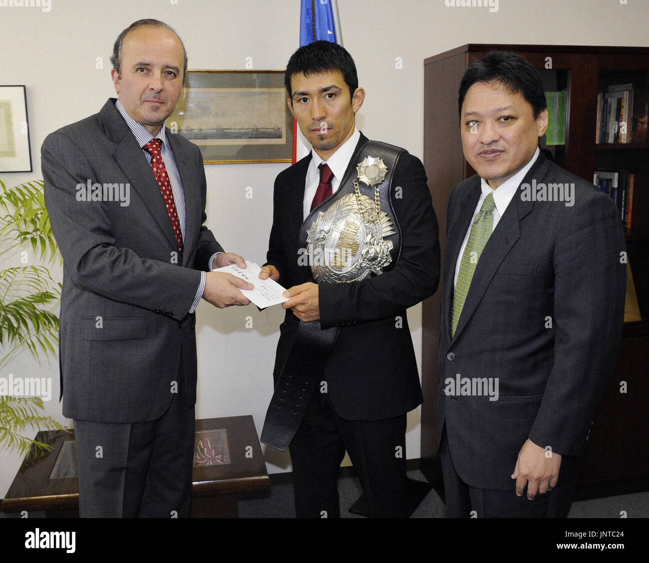 TOKYO, Japan - Japanese welterweight champion Takejiro Kato (C) hands a ...