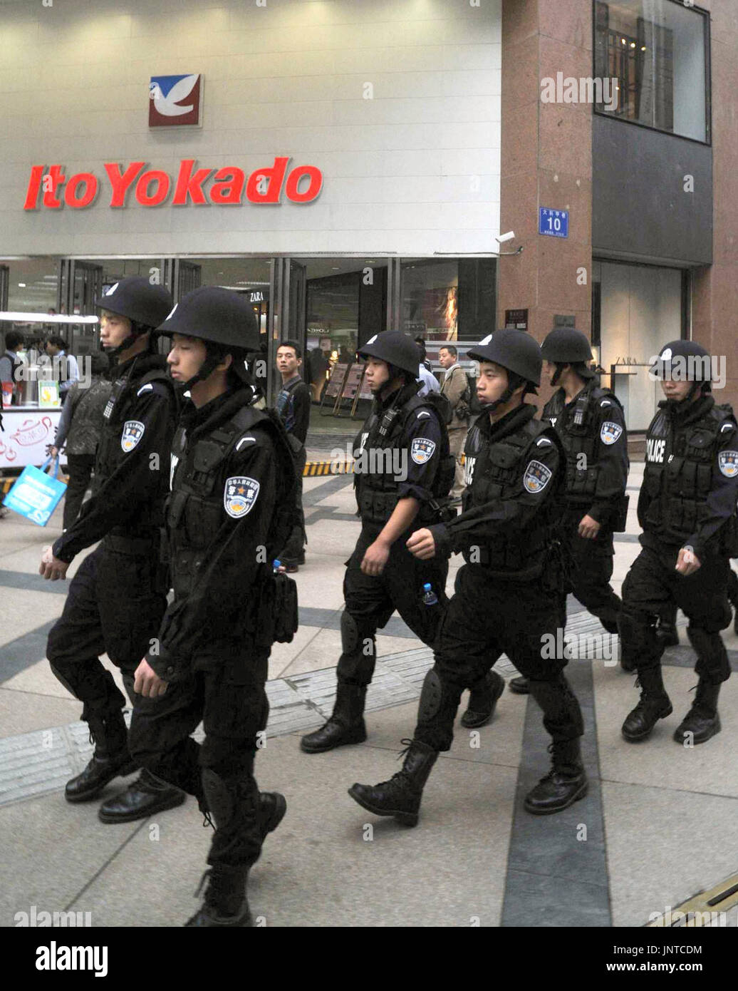 CHENGDU, China - Police officers patrol in front of a store operated by ...