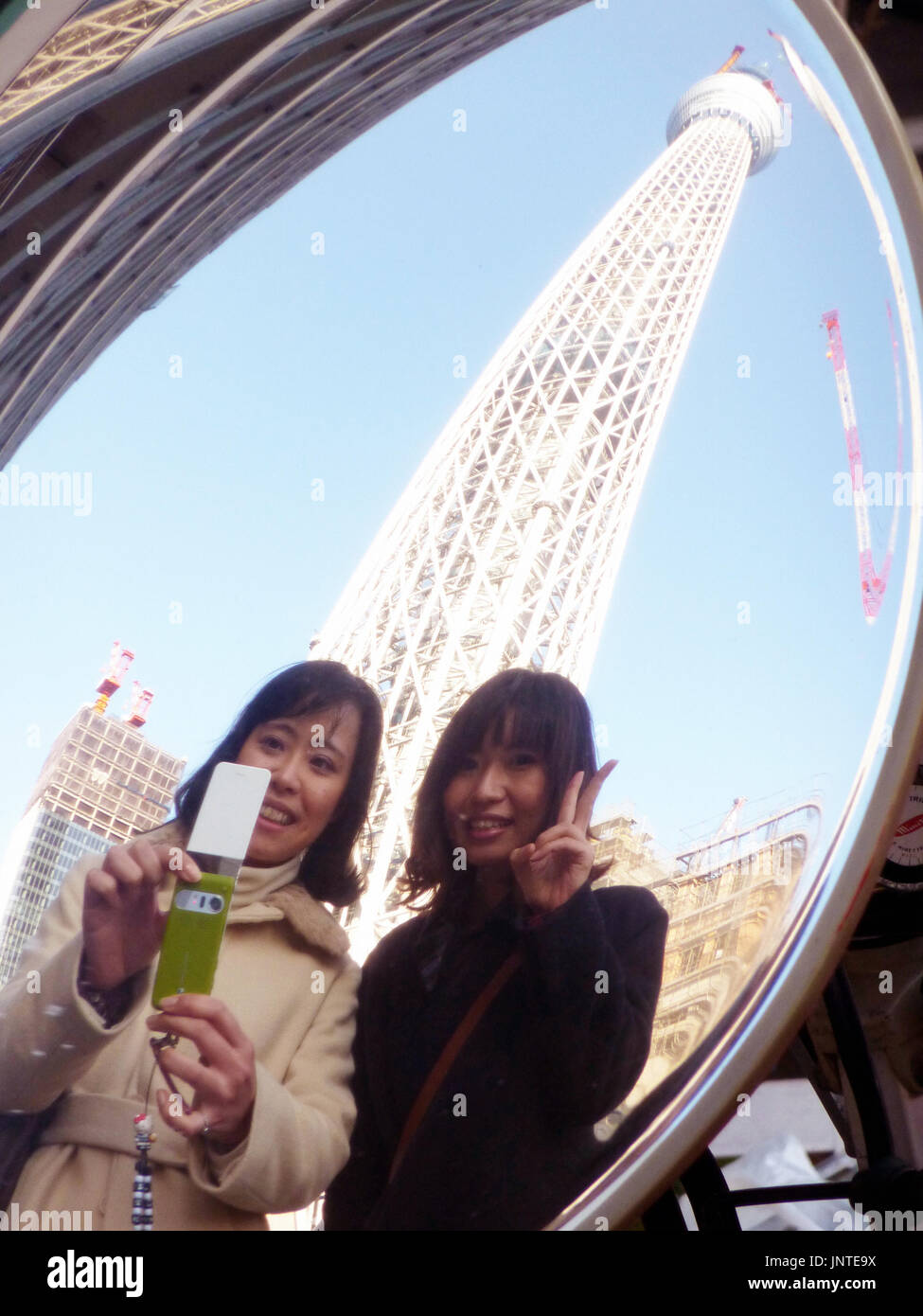 TOKYO, Japan - Women pose for a photo in front of a fish-eye mirror at ...