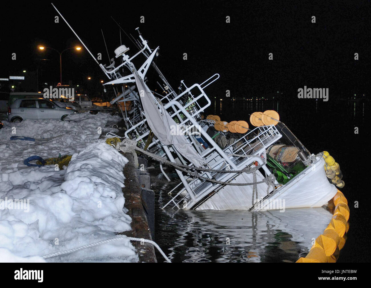 YONAGO, Japan - A fishing boat leans and submerges under the weight of ...